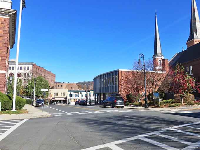 Downtown North Adams blends historic brick buildings with modern touches, creating a skyline where church steeples and contemporary architecture dance together under brilliant blue skies.