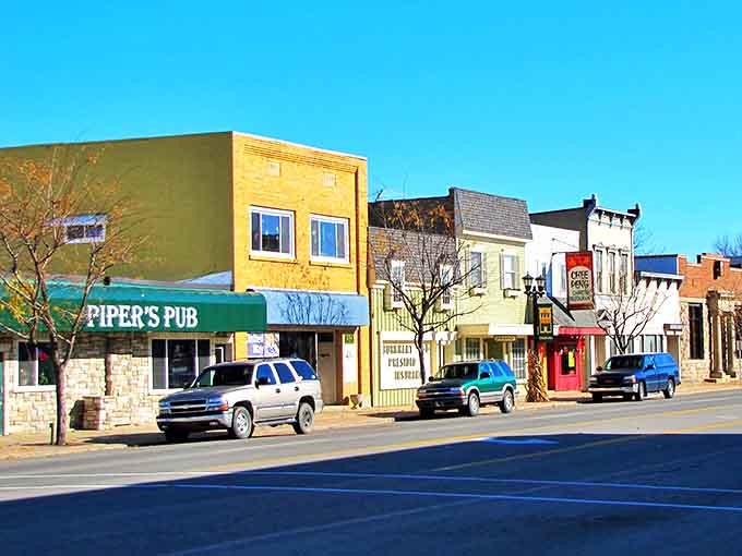 Downtown Gladwin's colorful storefronts stand like a cheerful lineup of old friends, where Piper's Pub promises cold drinks and warm conversations on sunny Michigan afternoons.