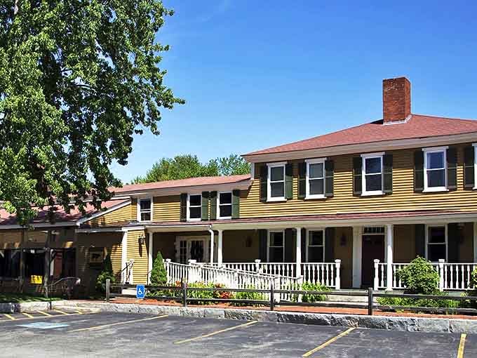 The charming yellow colonial building housing Buckley's Great Steaks welcomes diners with its inviting front porch and historic New England character.