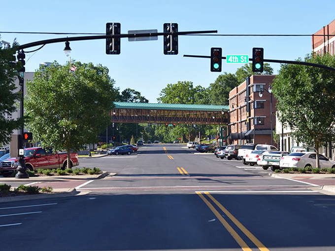 Downtown Sheffield welcomes visitors with its charming streetscape, where historic brick buildings frame the view and a pedestrian bridge connects the community.