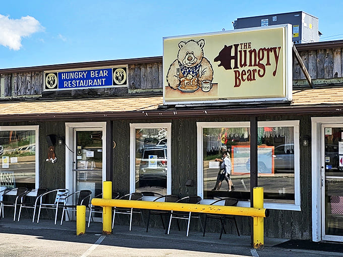 The rustic wooden exterior with bright yellow barriers offers outdoor seating for enjoying mountain air with your hearty, affordable breakfast.