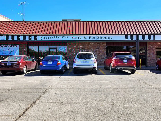 The unassuming brick exterior of Stauffer's Cafe & Pie Shoppe proves once again that culinary treasures often hide in plain sight, nestled between parked cars and modest awnings.
