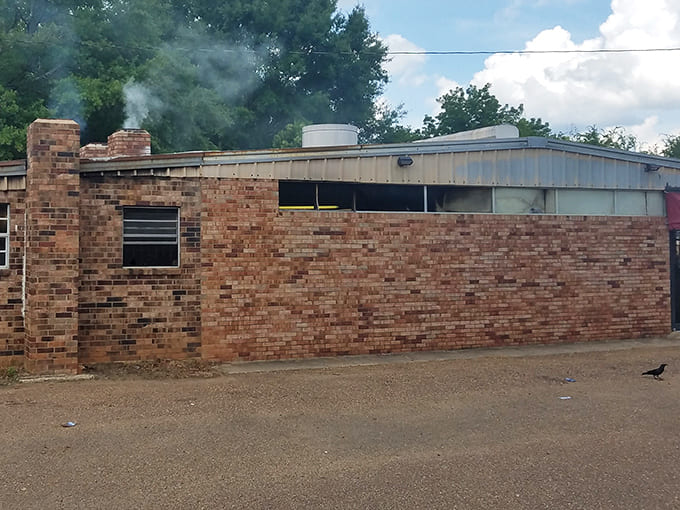 You can almost smell the decades of hickory smoke that have seasoned these walls. BBQ architecture at its most honest.
