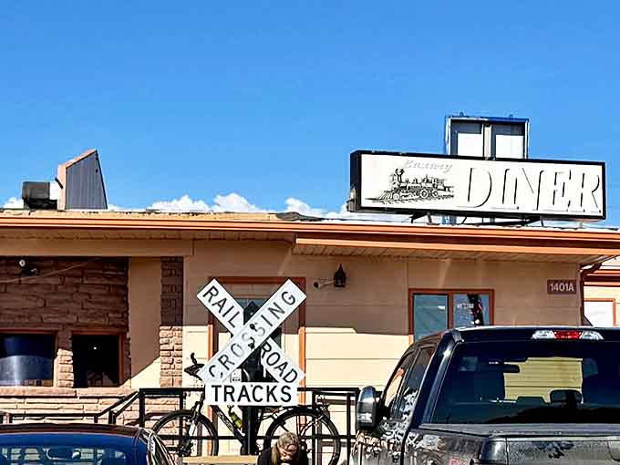 The Luxury Diner's iconic sign stands proudly against Wyoming's blue sky, with the railroad crossing sign below serving as a perfect metaphor&mdash;this is where great food and local history intersect.