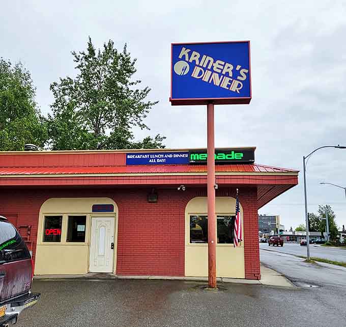 The iconic blue sign beckons hungry travelers like a lighthouse for breakfast lovers, promising comfort food salvation on Anchorage's C Street.