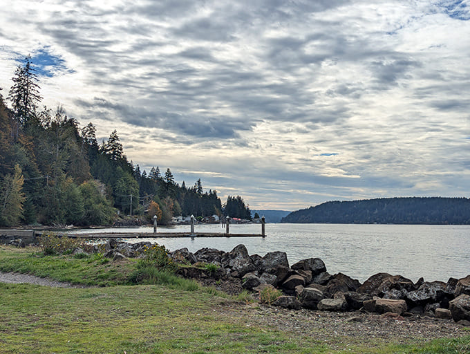 Dramatic clouds create a moody backdrop over Hood Canal's shoreline, showcasing Twanoh's beauty even on overcast days.