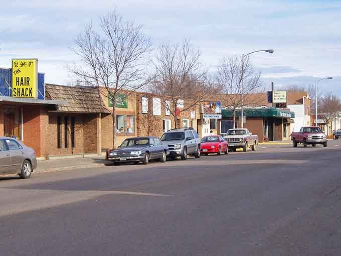 The Hair Shack anchors this stretch of small-town storefronts, where parking spots are plentiful and hurrying is optional.