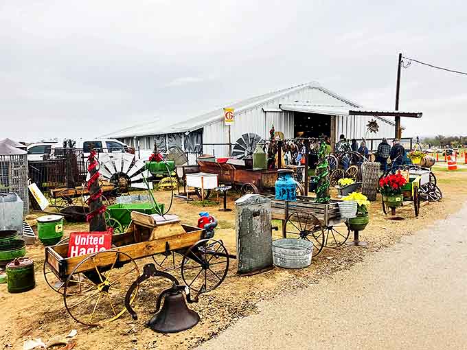 Outside this unassuming metal barn lies a treasure hunter's paradise where vintage wagons and garden art create the perfect Texas welcome committee.