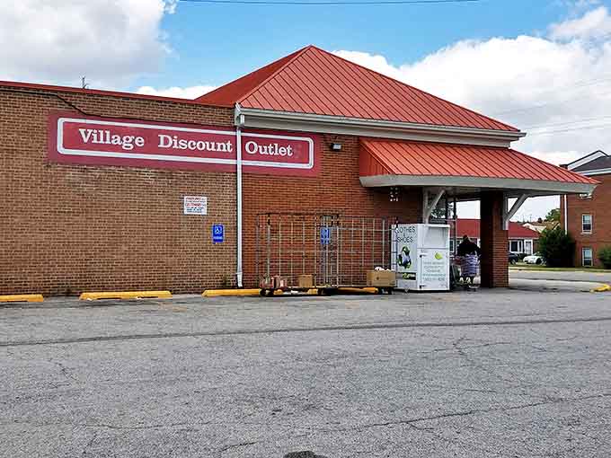 The iconic red roof of Village Discount Outlet beckons bargain hunters like a lighthouse guiding ships to treasure-filled shores. No fancy frills, just fantastic finds waiting inside.