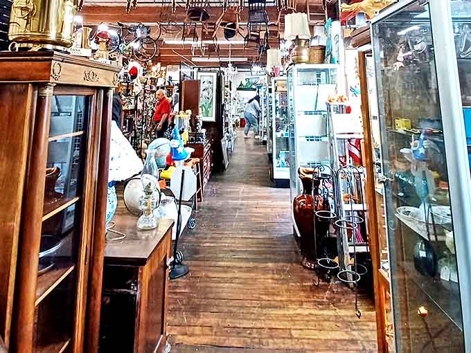 Narrow aisles create a treasure hunter's paradise where vintage lamps dangle overhead like conversation starters waiting to illuminate your next great find.