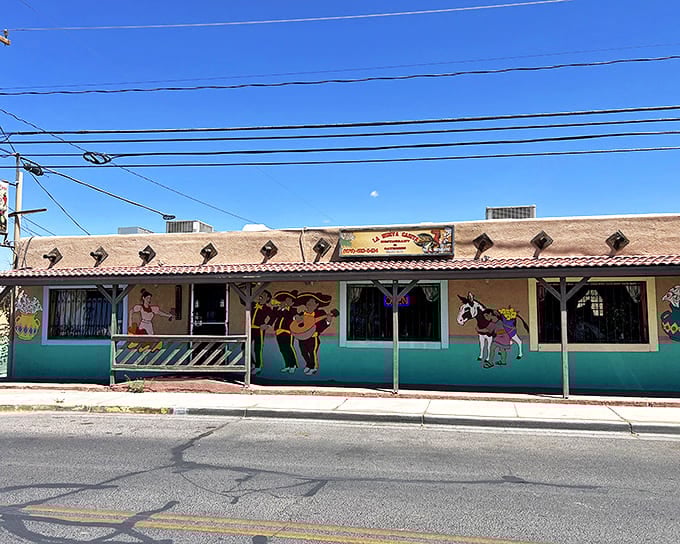 The turquoise-trimmed exterior of La Nueva Casita Caf&eacute; stands like a colorful oasis in Las Cruces, its vibrant murals promising authentic flavors within.