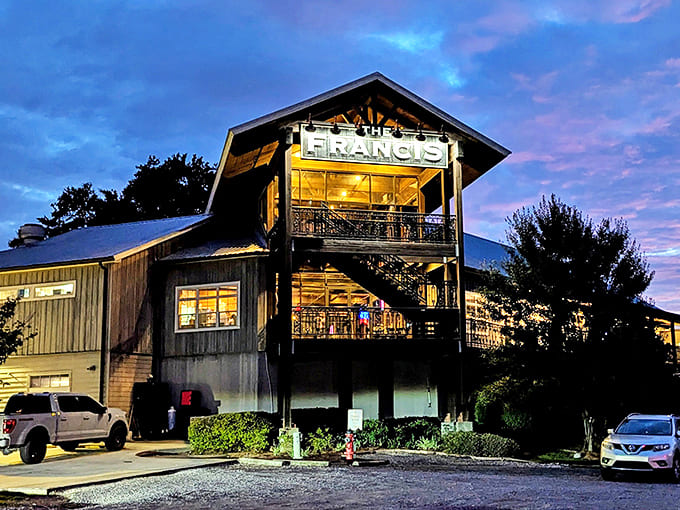 The Francis stands like a beacon against the twilight sky, its rustic-chic barn design promising culinary adventures within those warmly lit windows.