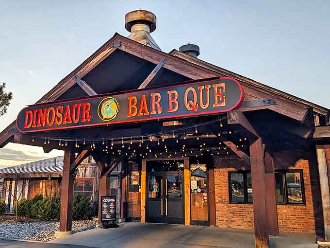 Smokestack symphony – the rugged brick exterior and industrial vents hint at the slow-smoked treasures waiting inside Dinosaur Bar-B-Que.