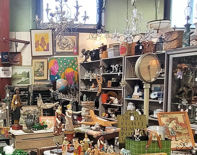 A treasure hunter's paradise: vintage art, chandeliers, figurines, and curiosities compete for attention in this densely packed vendor booth.