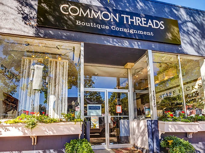 Sunshine dapples the storefront like nature's own Instagram filter, highlighting the boutique consignment shop's welcoming entrance and colorful planters.