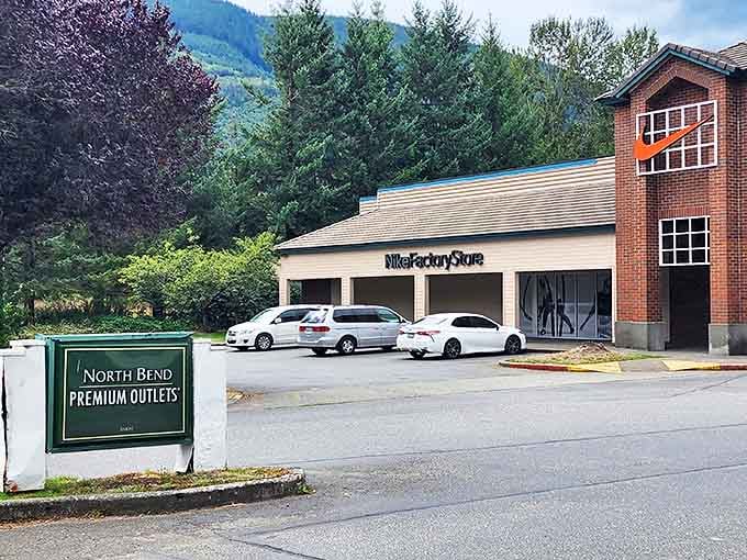 The welcoming entrance sign and Nike Factory Store beckon shoppers to discover amazing deals nestled against Washington's breathtaking evergreen backdrop.