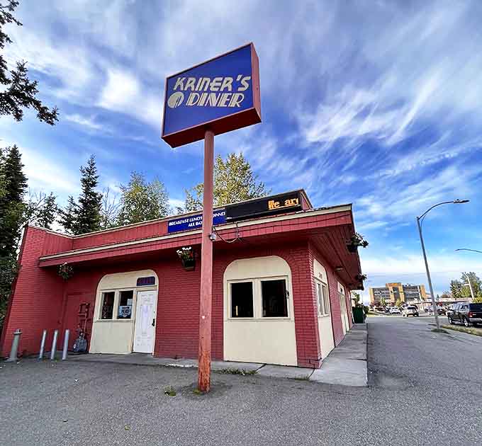 The bright blue sign of Kriner's Diner stands like a beacon of breakfast hope against Anchorage's sky, promising salvation for the hungry and caffeine-deprived.
