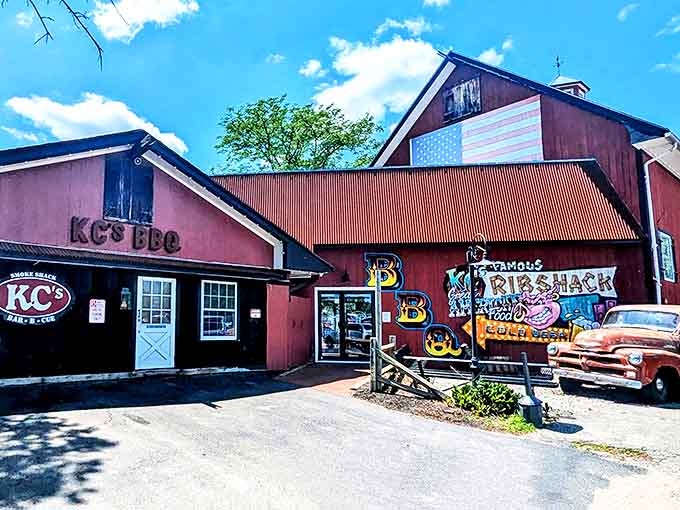 The barn-red exterior of KC's Rib Shack stands as a beacon of barbecue hope in Manchester, complete with vintage truck and American flag pride.