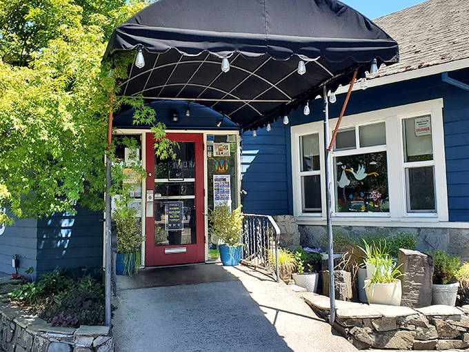 The entrance beckons with lush greenery and a black awning. Like a secret garden path leading to breakfast paradise.