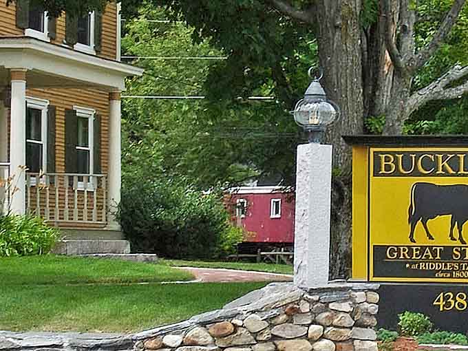 A stone entrance marker and distinctive yellow sign announce your arrival at Buckley's, where culinary excellence meets rustic charm.