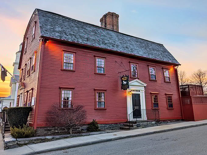 History painted crimson! The White Horse Tavern's colonial exterior glows at sunset, its weathered clapboard telling stories from 1673 that your history teacher never could.