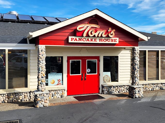 Bathed in sunshine, Tom's distinctive red gable and stone columns create the perfect rustic-meets-comfort vibe &ndash; like a mountain lodge that decided pancakes were its true calling.