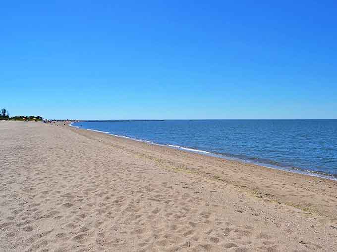 Two miles of golden perfection stretch toward the horizon, where Connecticut beachgoers find their slice of coastal heaven without the Hamptons price tag.