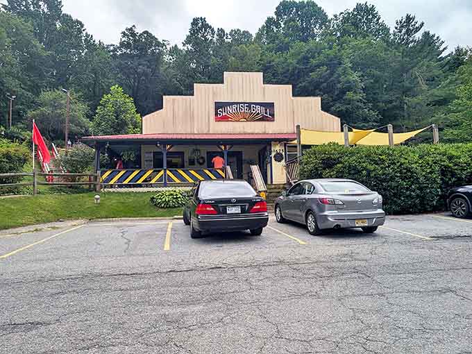 The stepped roofline of Sunrise Grill stands like a mountain range against the Carolina blue sky, promising breakfast adventures within those cheerful blue-and-yellow railings.