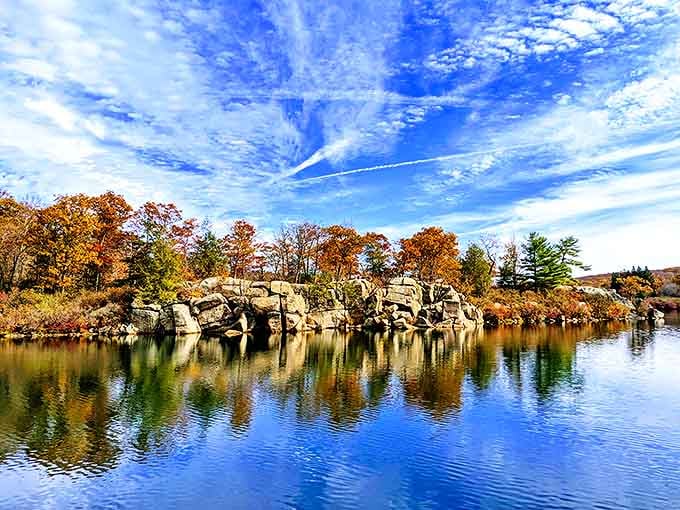 Nature's perfect mirror: autumn foliage and rugged rock formations create a double masterpiece on Harriman's tranquil waters. The sky's dramatic clouds complete this triple threat of beauty.