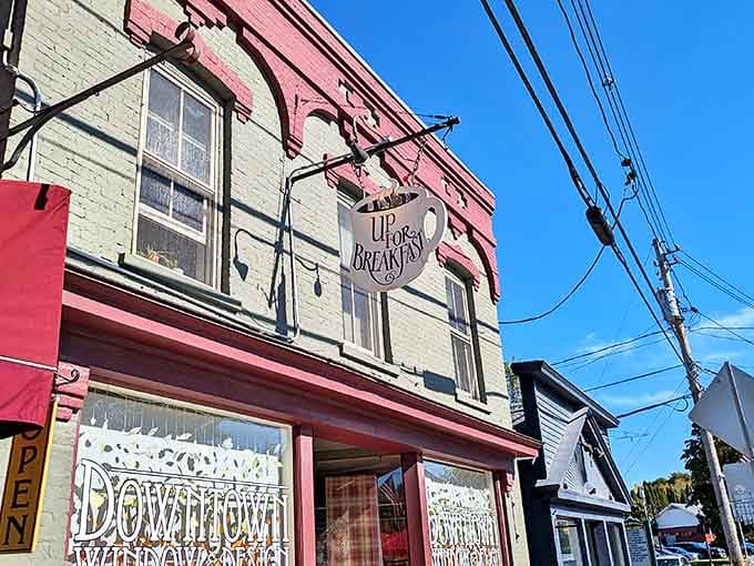 That coffee cup sign hanging above the street isn't just cute d&eacute;cor&mdash;it's a beacon of hope for morning zombies desperately seeking caffeine salvation in downtown Manchester.
