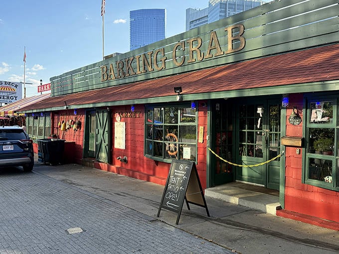 The iconic red shack stands proudly against Boston's skyline, like a cheerful lobster that refused to wear a business suit to the Financial District meeting.
