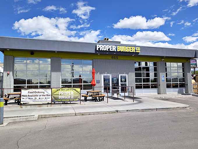 The modern industrial exterior of Proper Burger Co. might not scream "food paradise," but that blue Utah sky promises something special awaits inside.