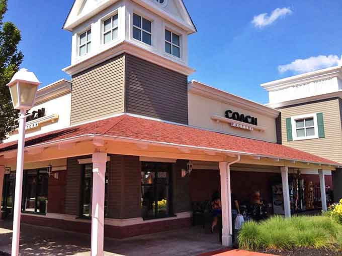 Coach's welcoming storefront combines classic American luxury with outlet pricing&mdash;a dangerous combination for leather goods enthusiasts. That covered entrance practically pulls you in like a tractor beam.