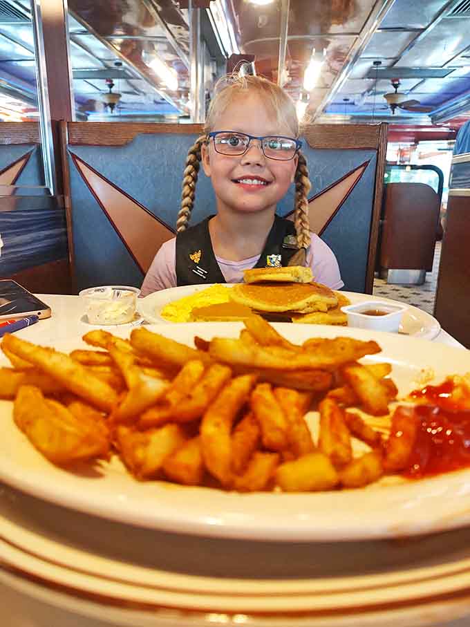 The diner booth—where family memories are made one pancake stack at a time. Notice nobody's looking at their phones?