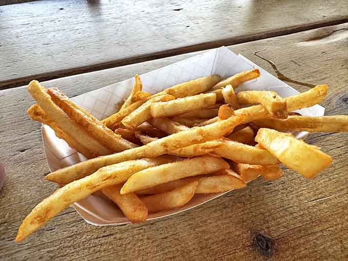 Fries so perfectly golden they deserve their own spotlight, crisp enough to maintain dignity even after the last bite of fish is gone.