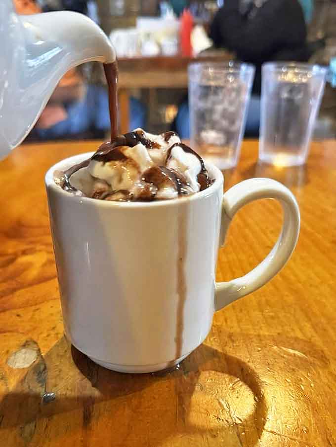 Hot chocolate elevated to an art form. That river of maple syrup cascading over whipped cream isn't just a drink &ndash; it's a warm hug in a mug.