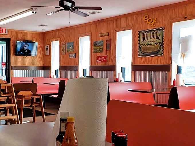 Orange booths and wood paneling create that timeless diner atmosphere where conversations flow as freely as the sweet tea. No designer needed, just decades of getting it right.