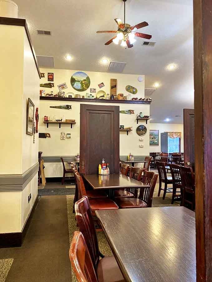 Dark wood tables and chairs stand ready for the next round of diners, like an orchestra pit before the symphony of clinking forks begins.