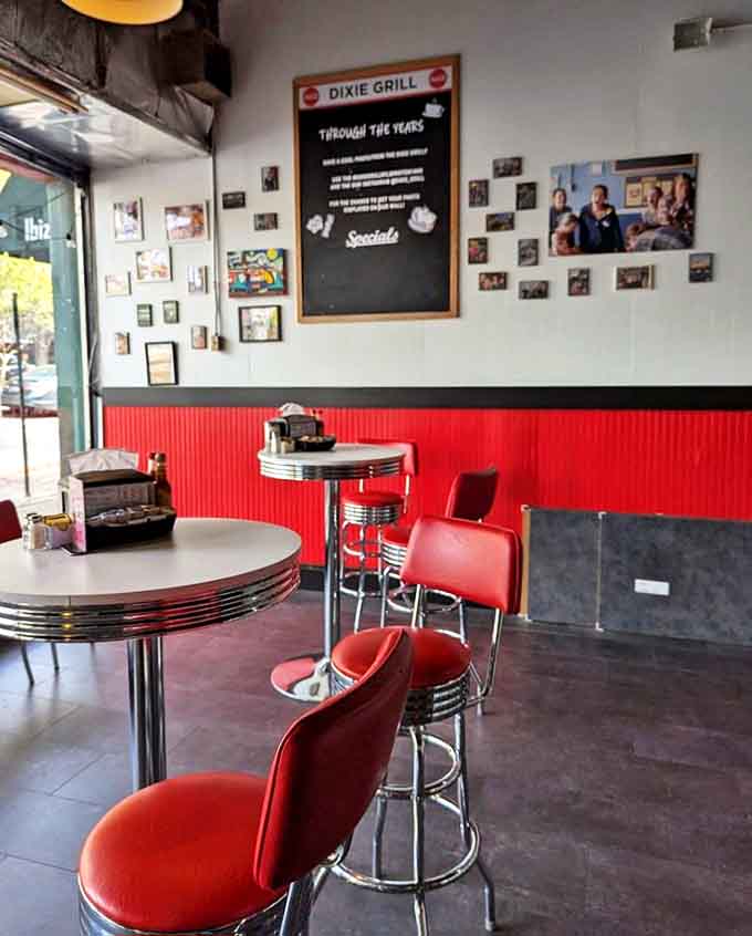 Red vinyl stools and retro tables create the perfect backdrop for morning rituals. The wall of memories shows you're dining in a true local landmark.