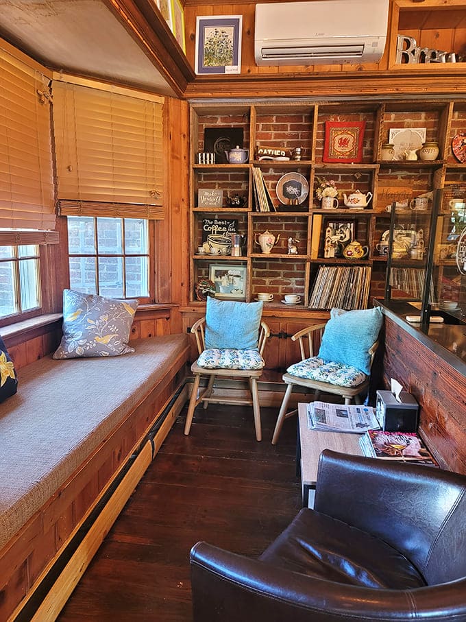 This cozy nook with wooden accents, blue cushions, and a collection of coffee memorabilia feels like the living room you wish you had&mdash;if your living room served perfect lattes.