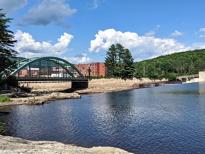 The green arched bridge spans the Androscoggin with elegant simplicity, connecting neighborhoods while providing the perfect spot for contemplative river-watching.
