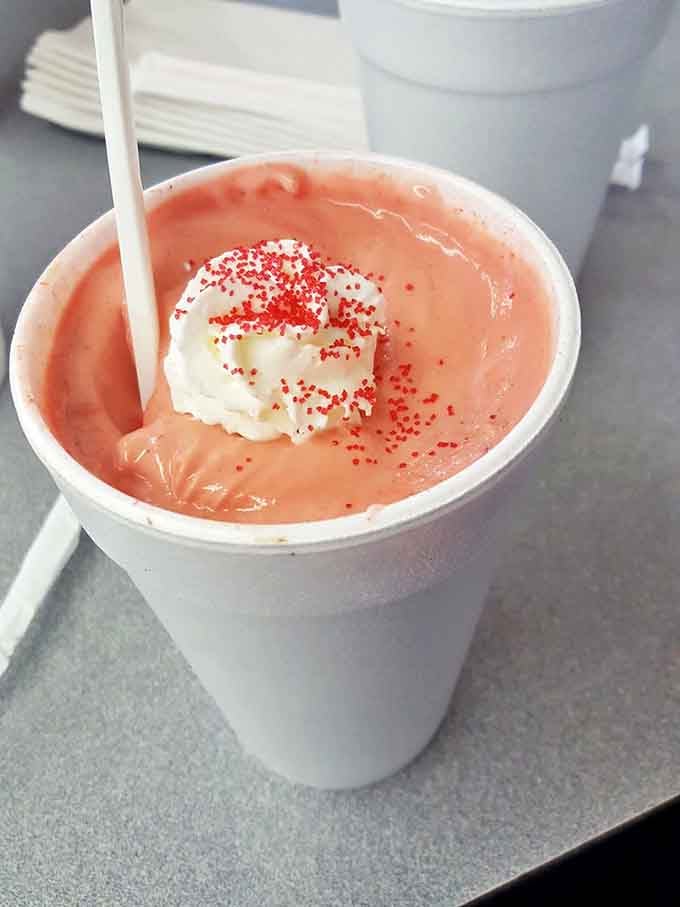 A strawberry shake topped with whipped cream and sprinkles. Dessert masquerading as a beverage—the best kind of identity crisis.
