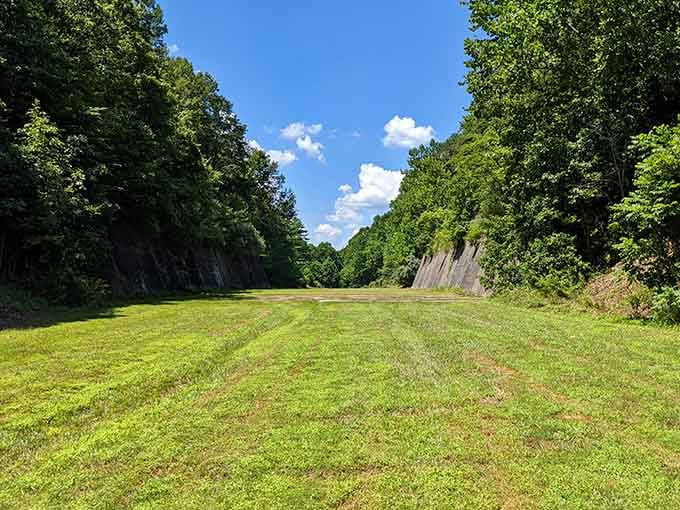 This grassy corridor carved between towering rock walls feels like walking through nature's grand hallway to the most spectacular living room.