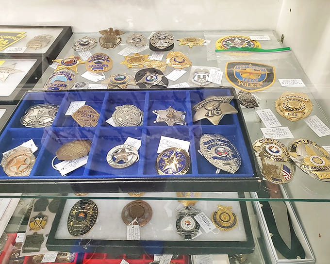 Law enforcement badges spanning decades tell silent stories of service. Each star and shield represents chapters of American history rarely displayed together.