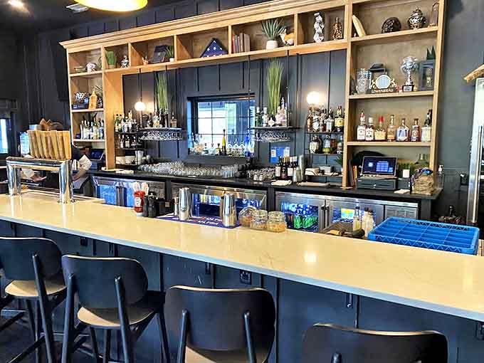 The sleek bar area balances rustic wooden shelving with modern touches, creating a space where mountain charm meets sophisticated sipping.