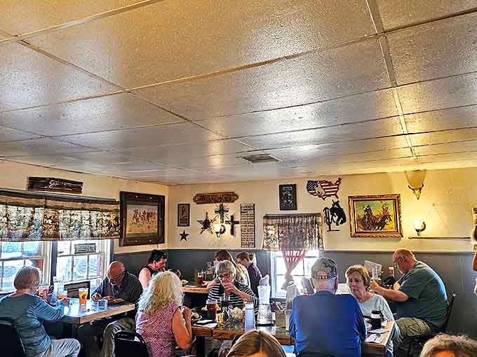 The Wild West Show poster watches over diners like a guardian of authenticity, ensuring no avocado toast ever infiltrates these hallowed walls.