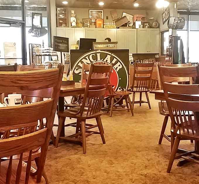 Vintage Sinclair sign anchors this cozy diner where wooden chairs await hungry patrons in nostalgic comfort.