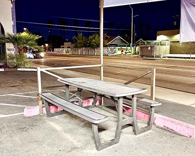 As night falls, the humble picnic table outside becomes prime real estate for those in the know. Urban dining with a side of desert stars.