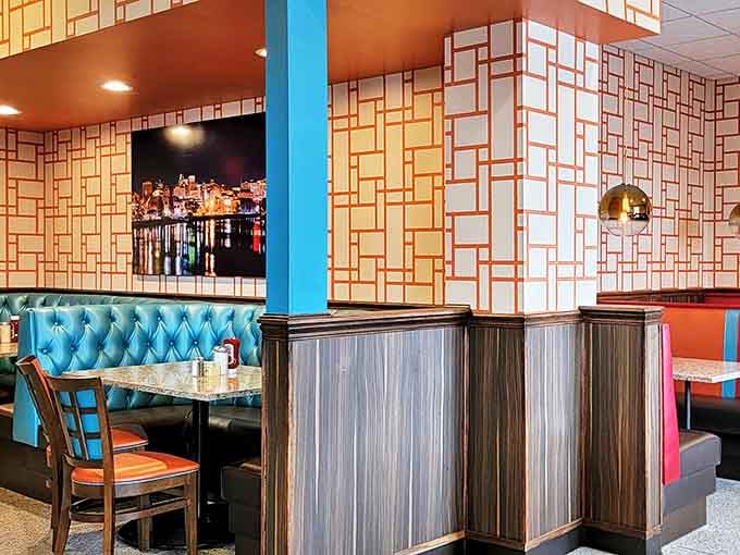 The geometric wallpaper and blue booth combo creates that perfect mid-century modern feel. Like Don Draper might slide in for a club sandwich any minute.