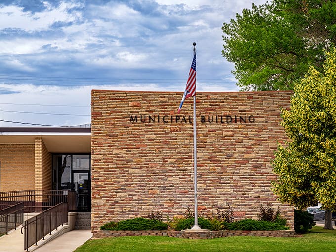 Powell's Municipal Building stands proudly with its brick facade and American flag under Wyoming's vast sky.